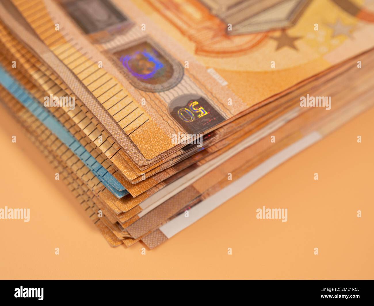 Money on an orange background. Euro paper banknotes. Close-up Stock ...