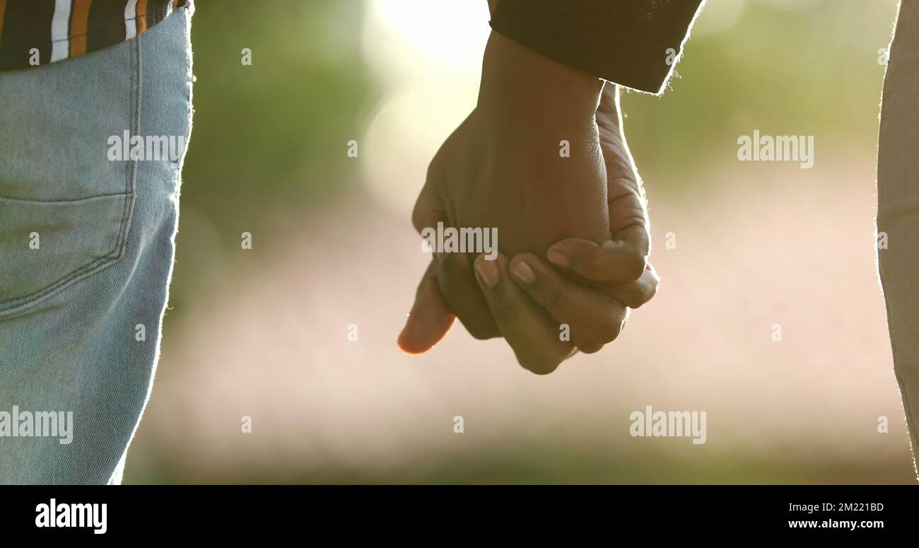 Close-up of hands joining together with sunlight flare in the ...