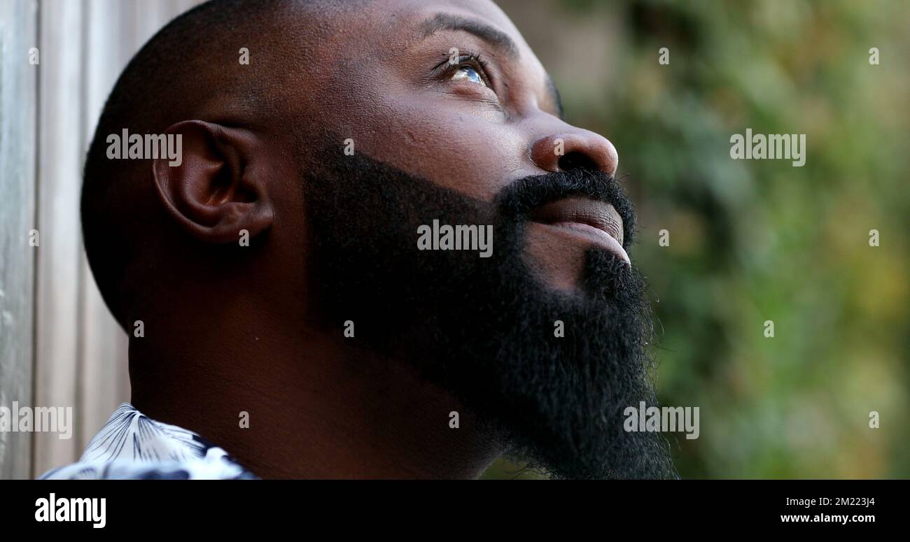 Happy optimistic black African man smiling looking at sky with HOPE and ...