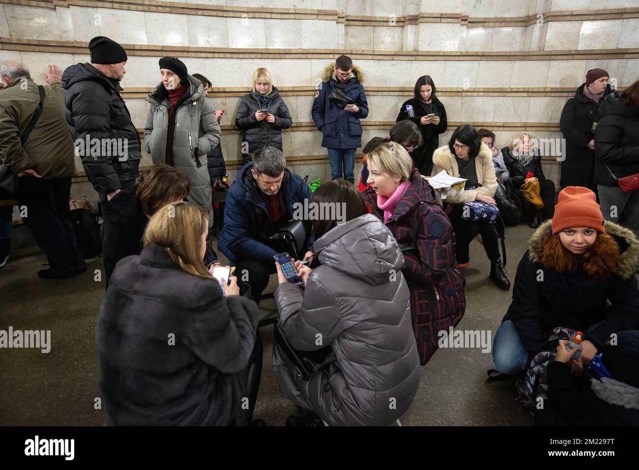 People with smartphones spend time inside a metro station during an air ...