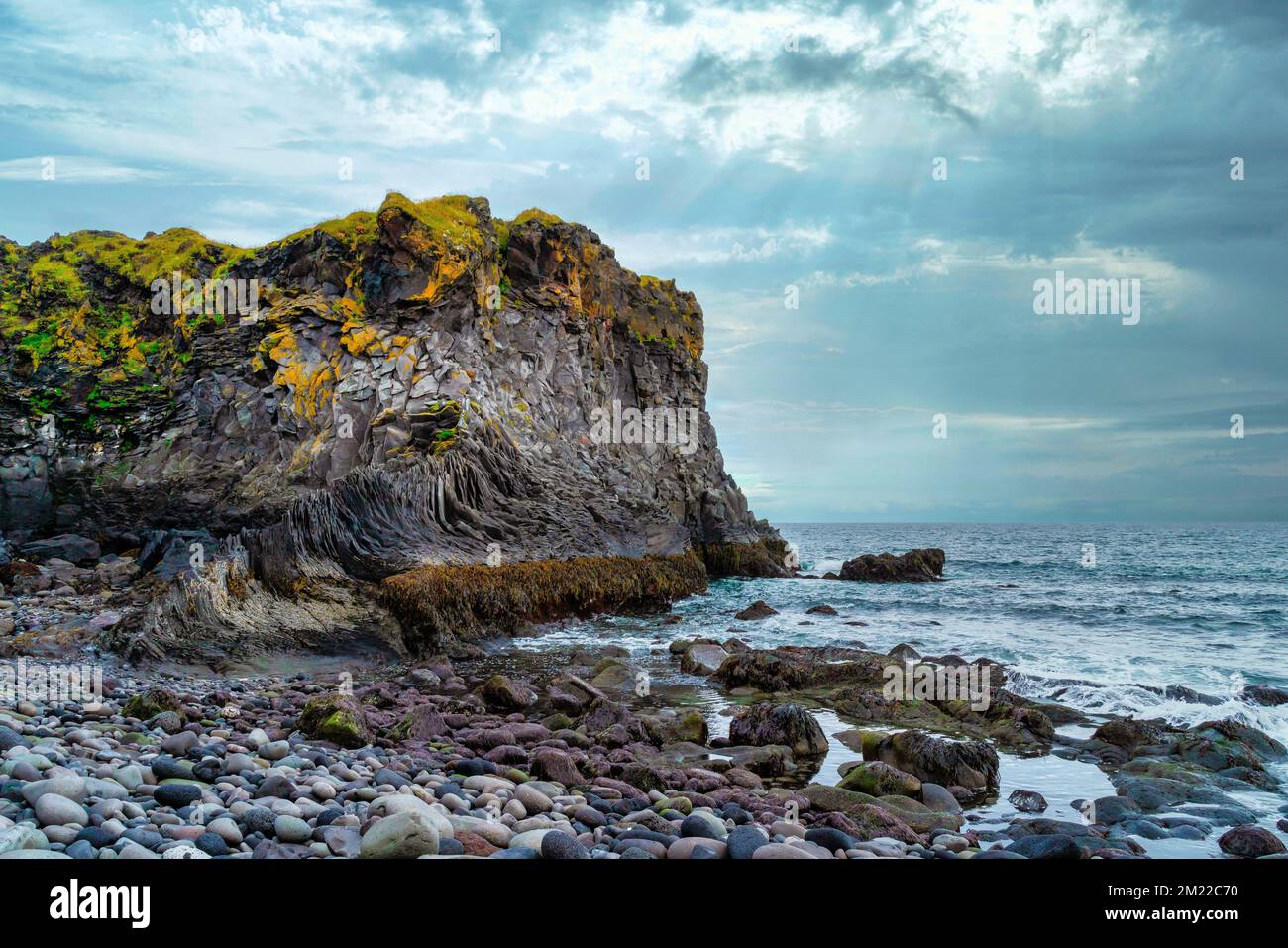 A beautiful view of a rocky shore with cliff under the cloudy sky Stock ...