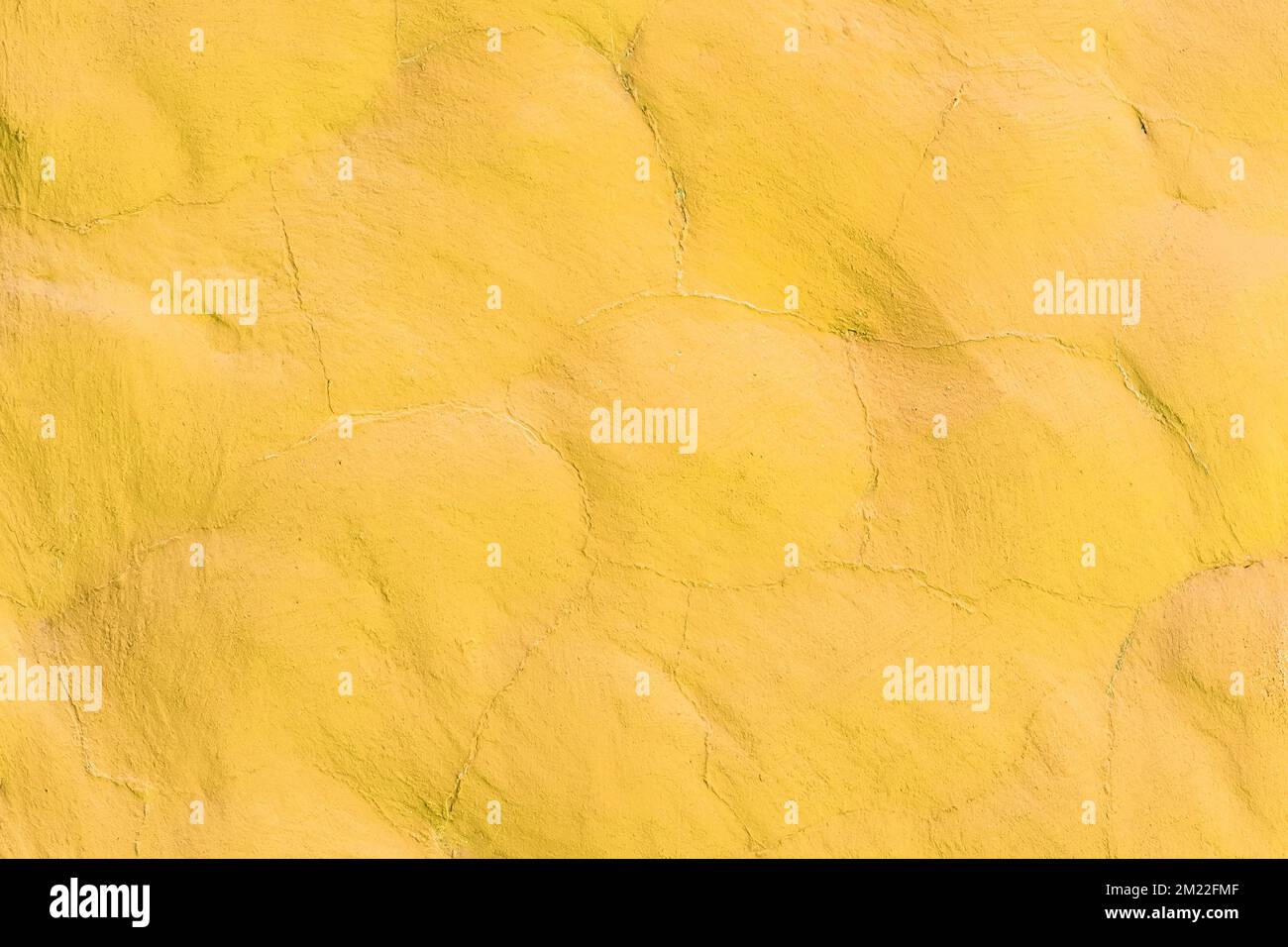 Yellow bright light vibrant paint on the stone surface wall texture ...