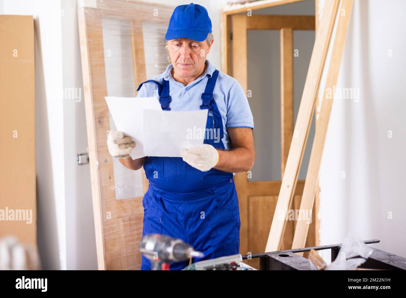 Man foreman checks the completed construction work on drawing Stock ...