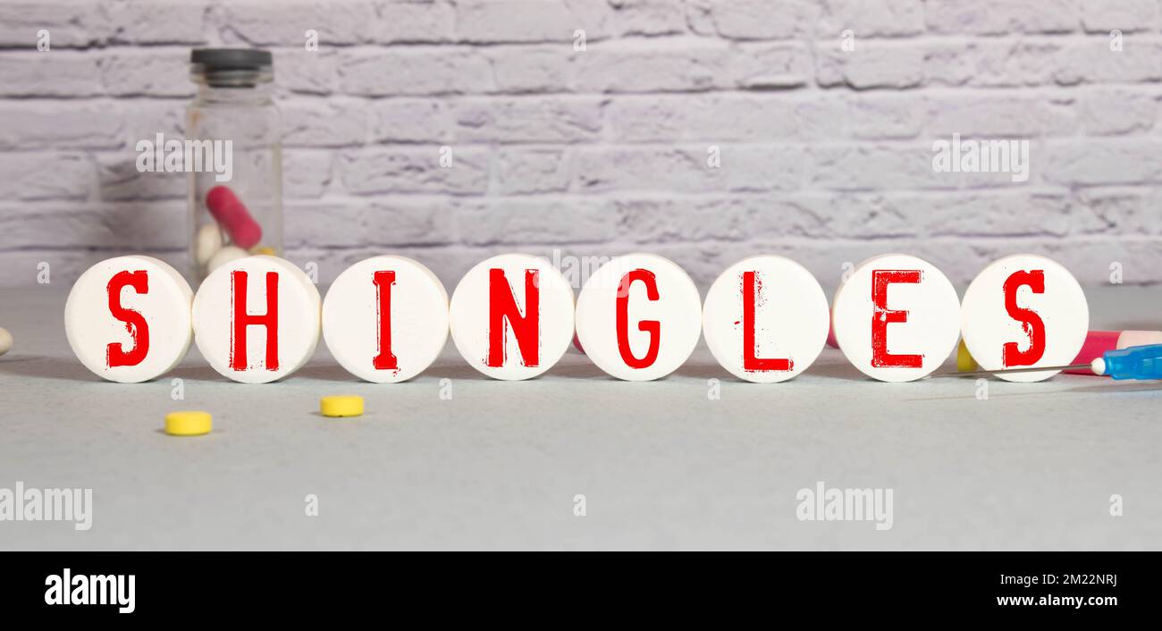 Shingles word written on wood block. Shingles text on cement table for ...