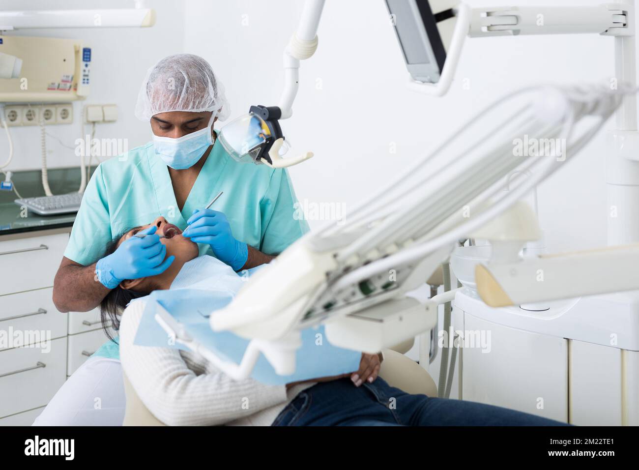 Male dentist performing teeth examination hi-res stock photography and ...