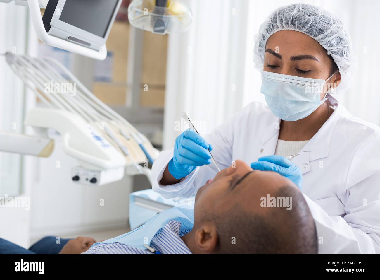 Dentist professional filling teeth for man patient sitting in chair ...