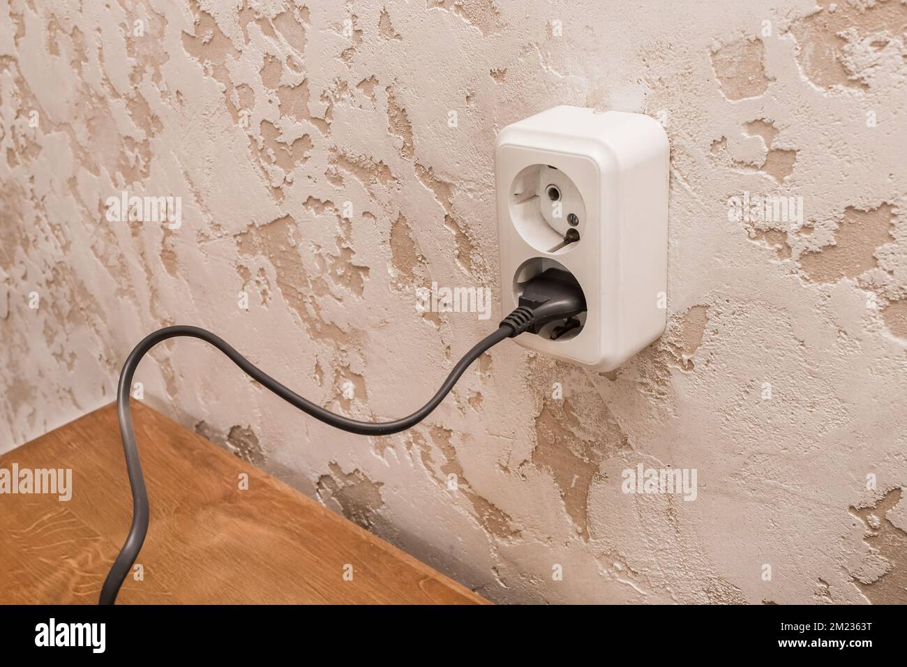 Plug in a double outlet on a white plaster background in a modern room ...