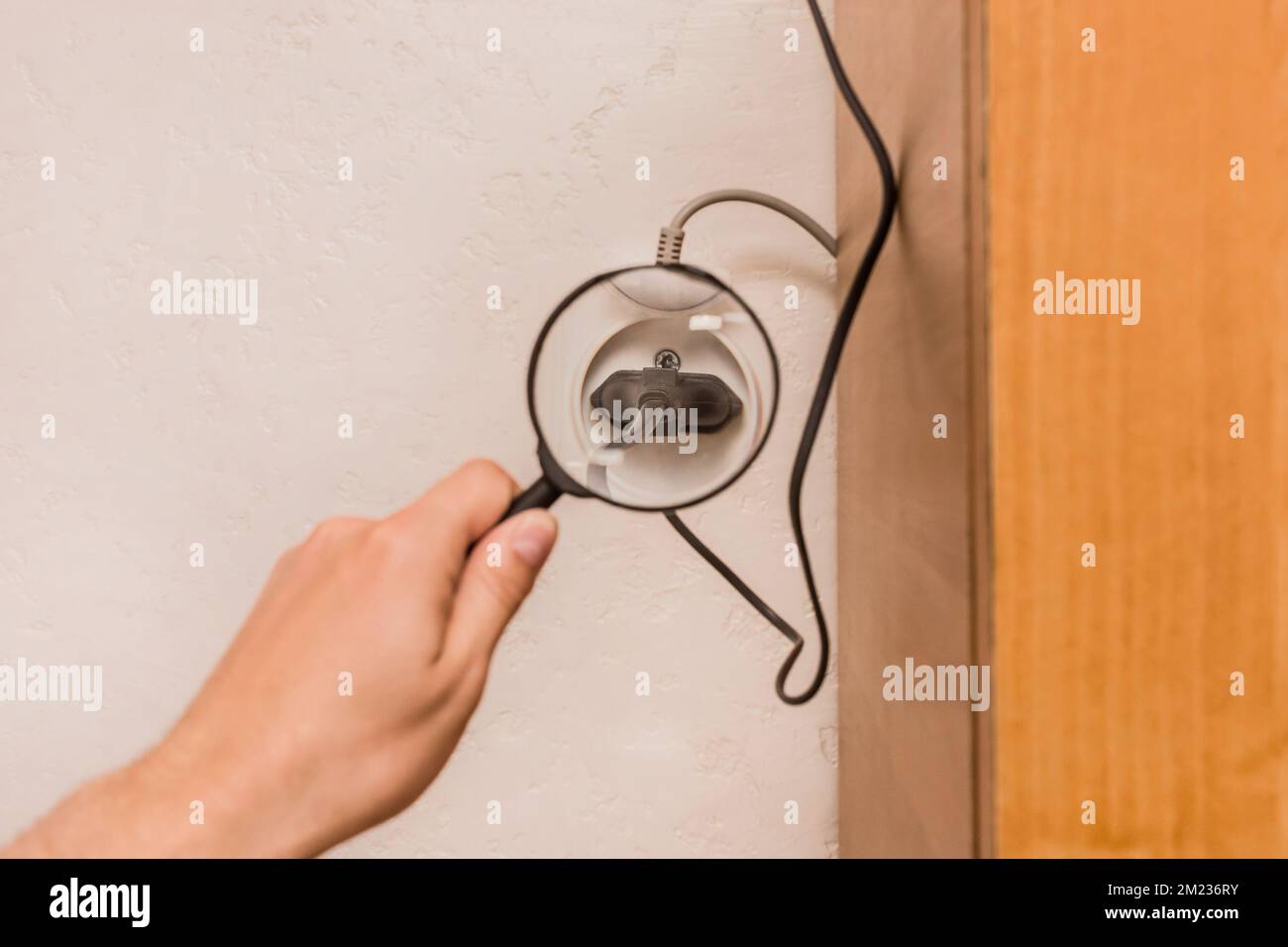 The hand of a male worker examines through a magnifying glass the ...