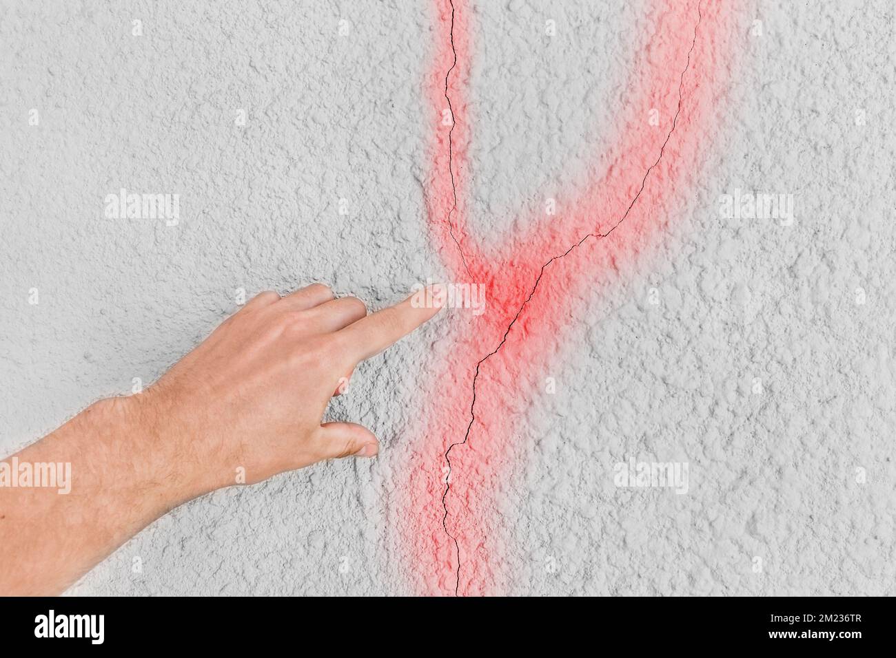Male construction worker hand points cracks on white broken wall ...
