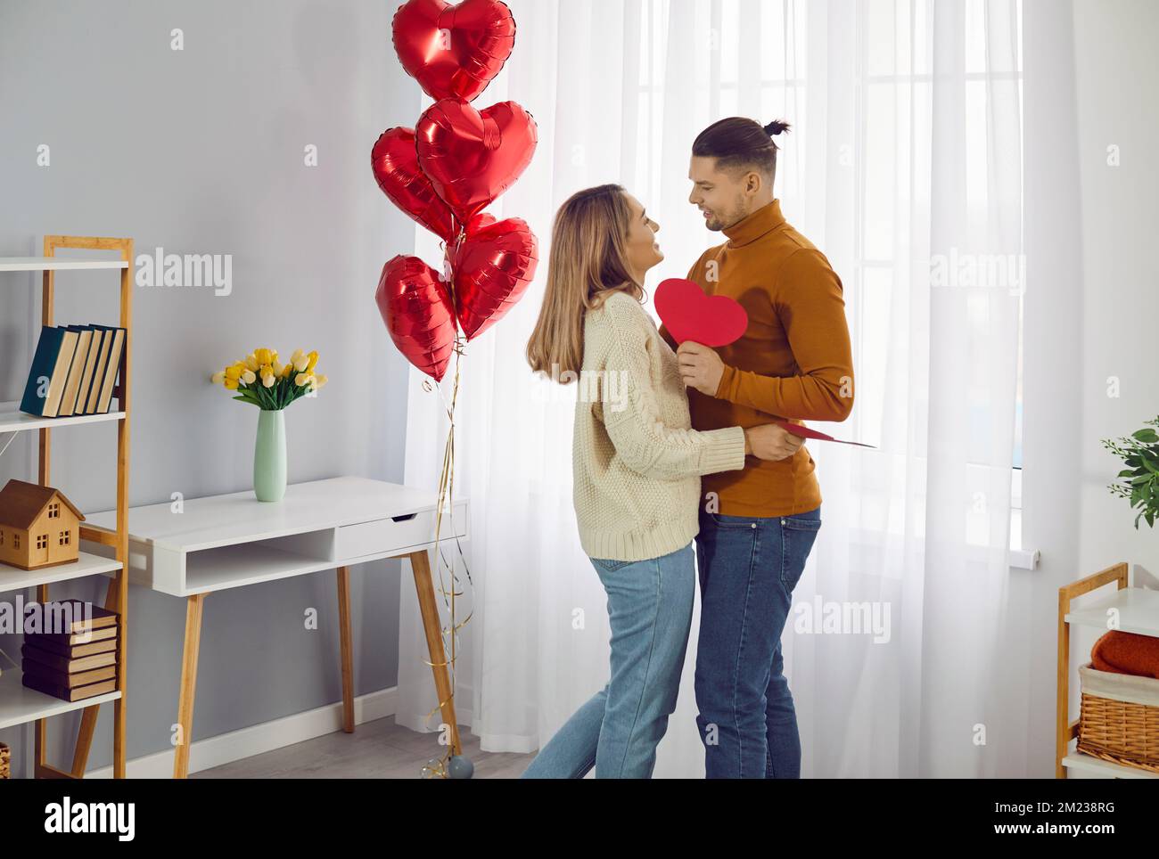 Happy loving couple spending Valentine's Day at home and giving each other presents Stock Photo ...
