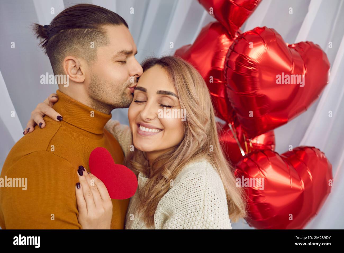 Young couple in love in romantic atmosphere hug and kiss each other ...
