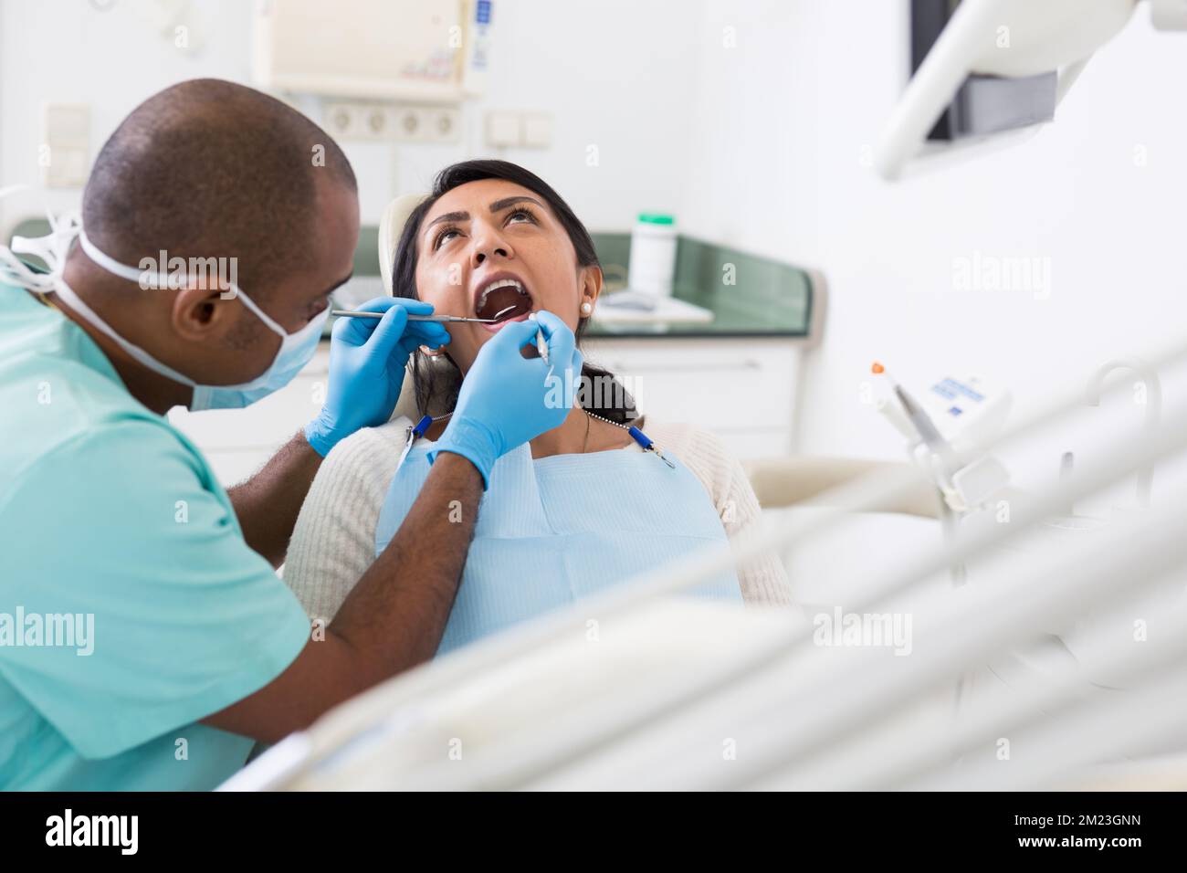 Dentist checking teeth of patient woman sitting in medical clinic Stock ...
