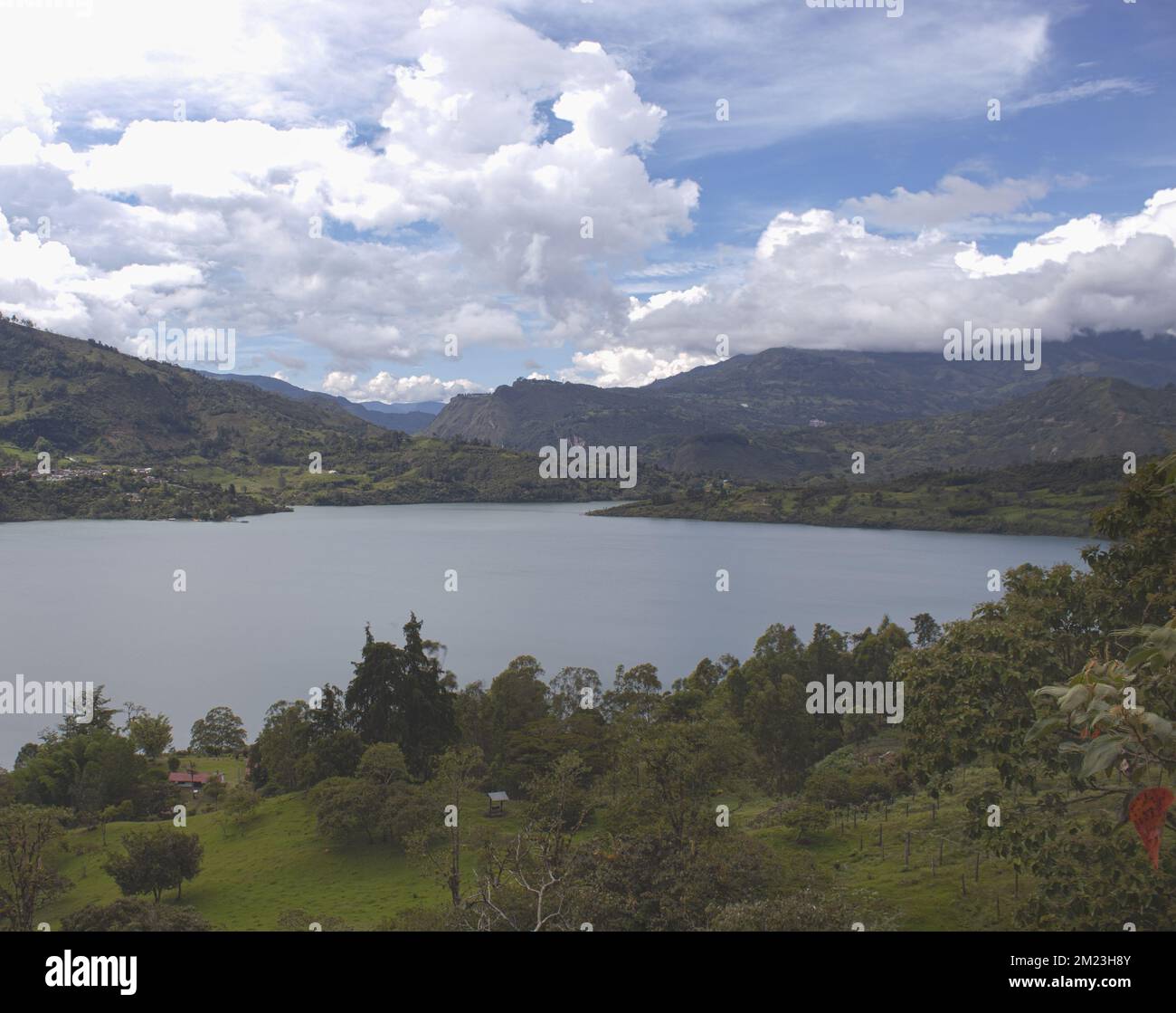 Colombian mountain and lake landscape with cloudy blue sky and andean ...