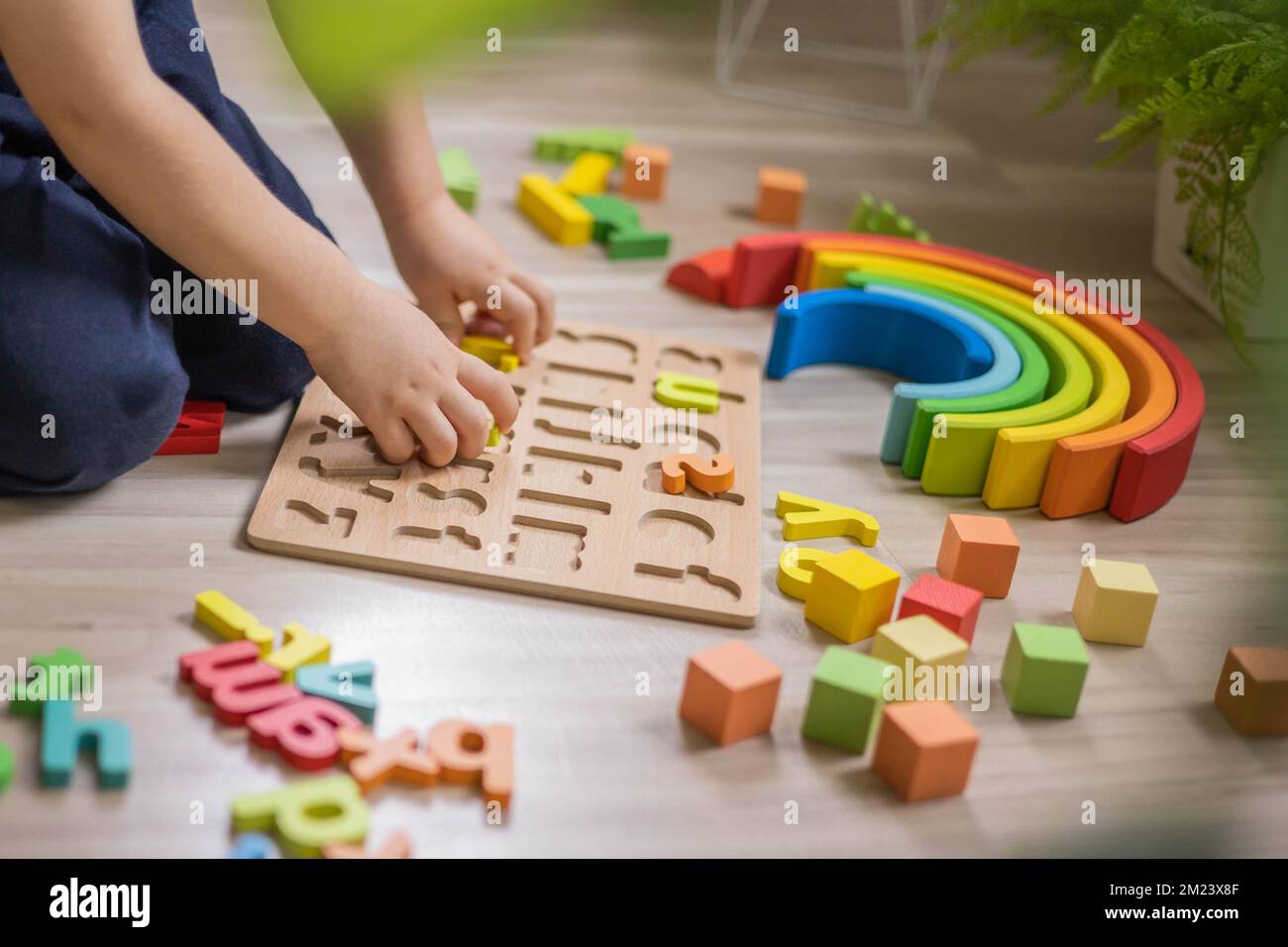 Male kid playing with wooden eco friendly alphabet letters board on ...