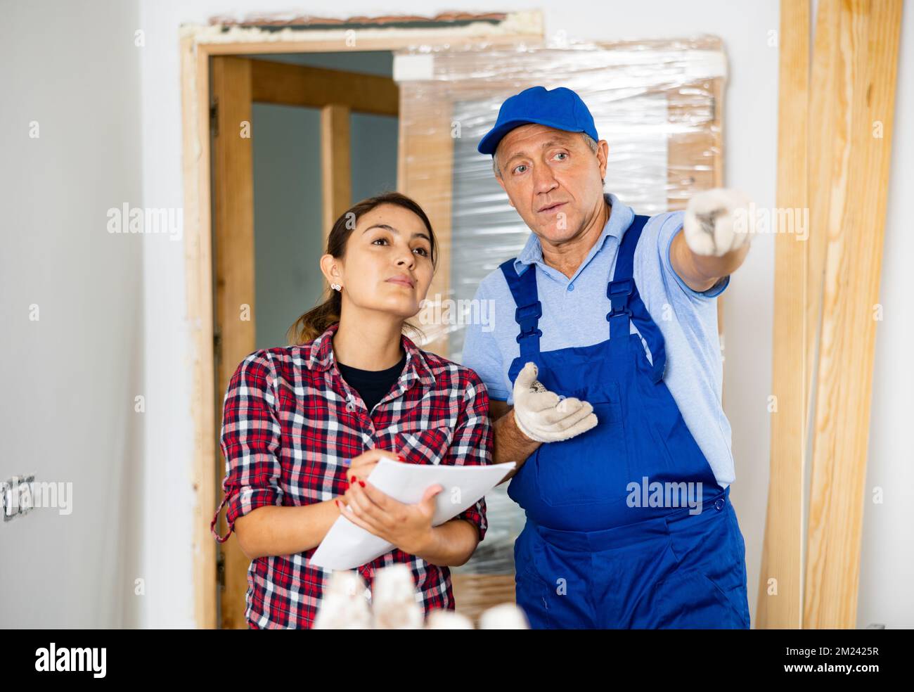 Man worker talking with woman owner of apartment about renovation works ...