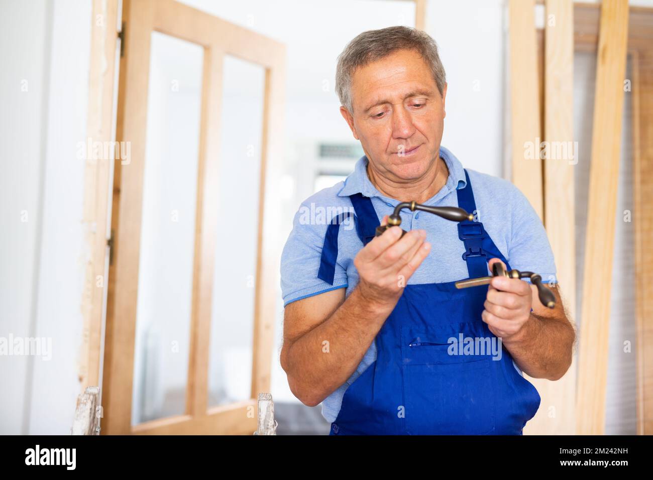 Professional door installer checks operation of bronze door handles ...
