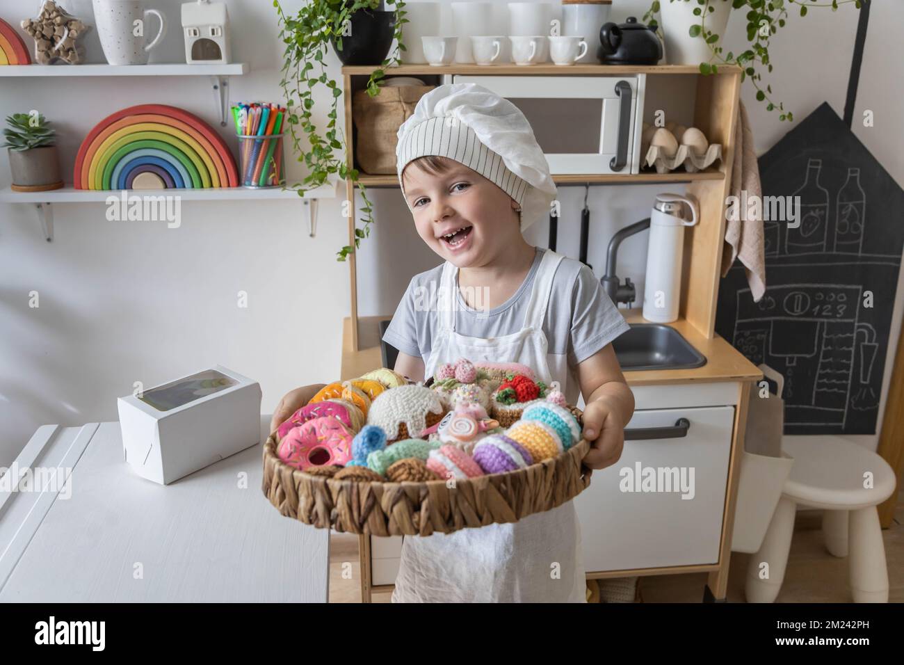 Portrait smiling male kid cafe chef posing with tray full sweet ...