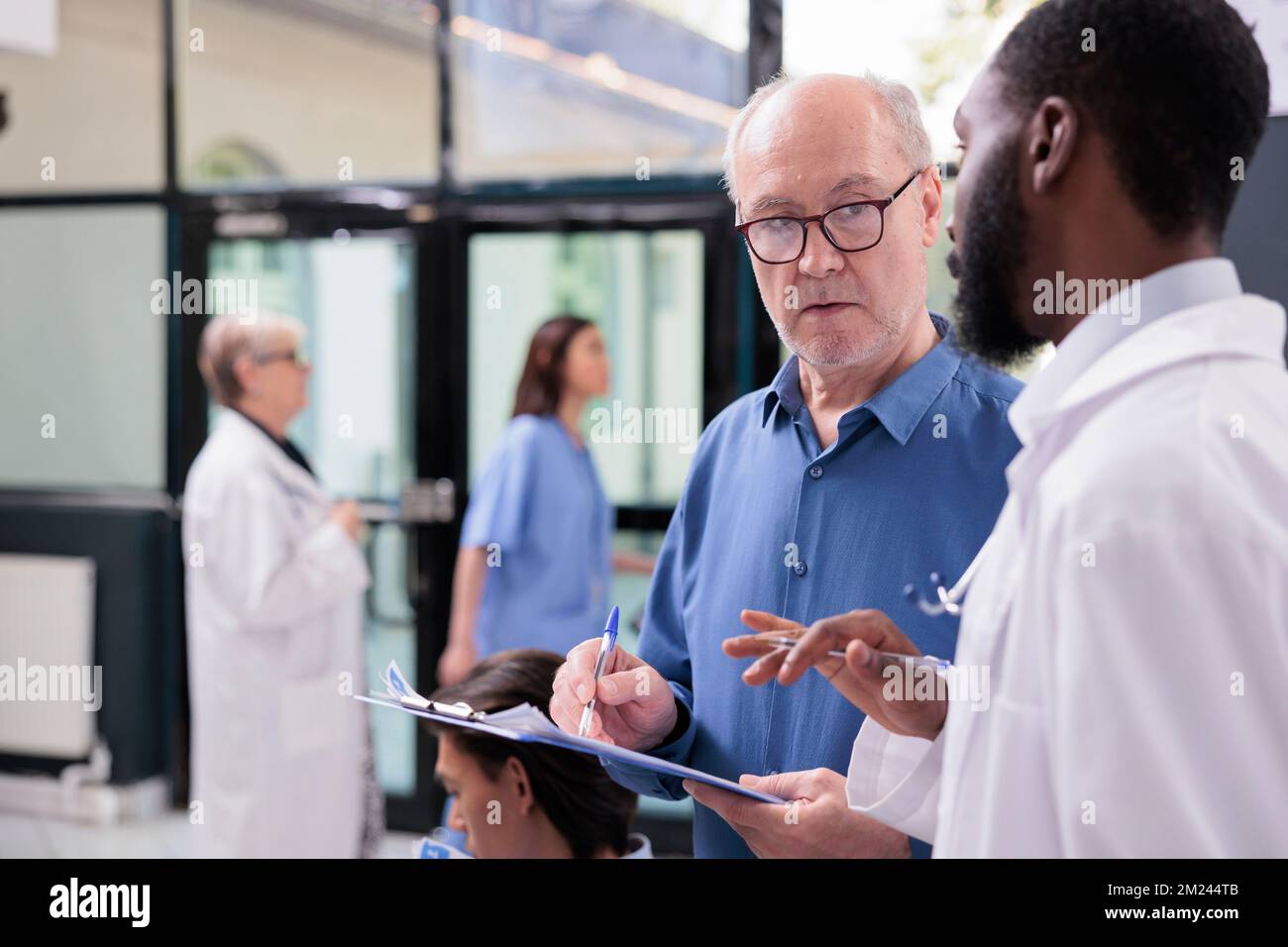 Doctor discussing health care treatment with senior patient during ...