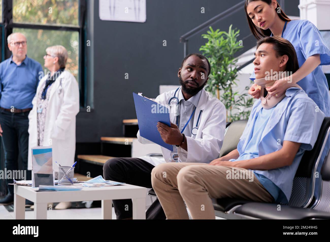 Nurse and elderly traumatologist helping injured asian patient with ...