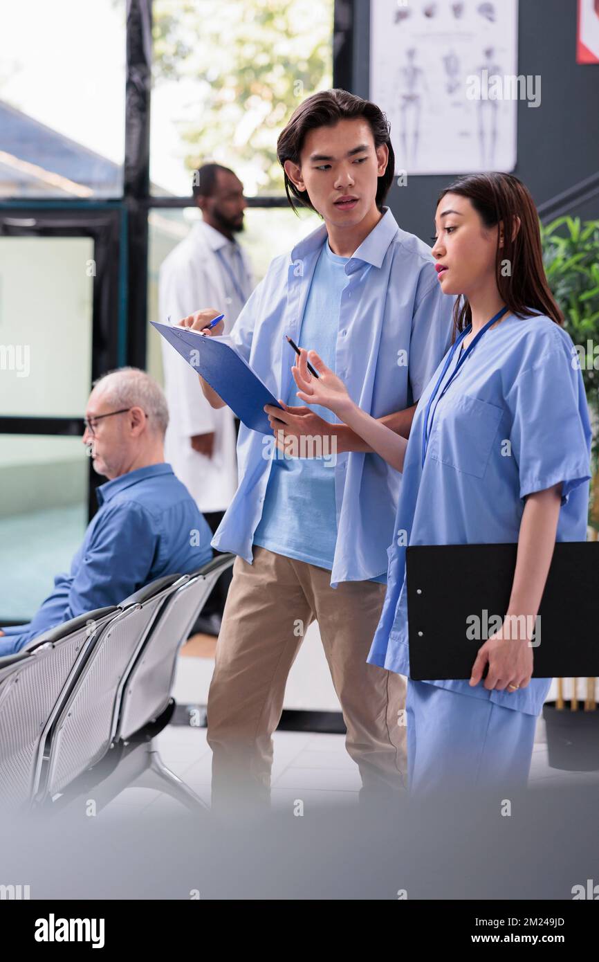 Physician nurse explaining medical expertise to asian patient after ...
