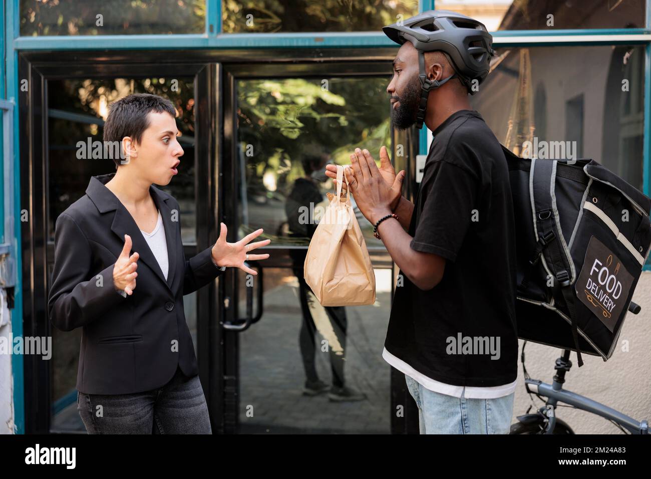 Woman shouting at office food delivery service courier, receiving wrong ...