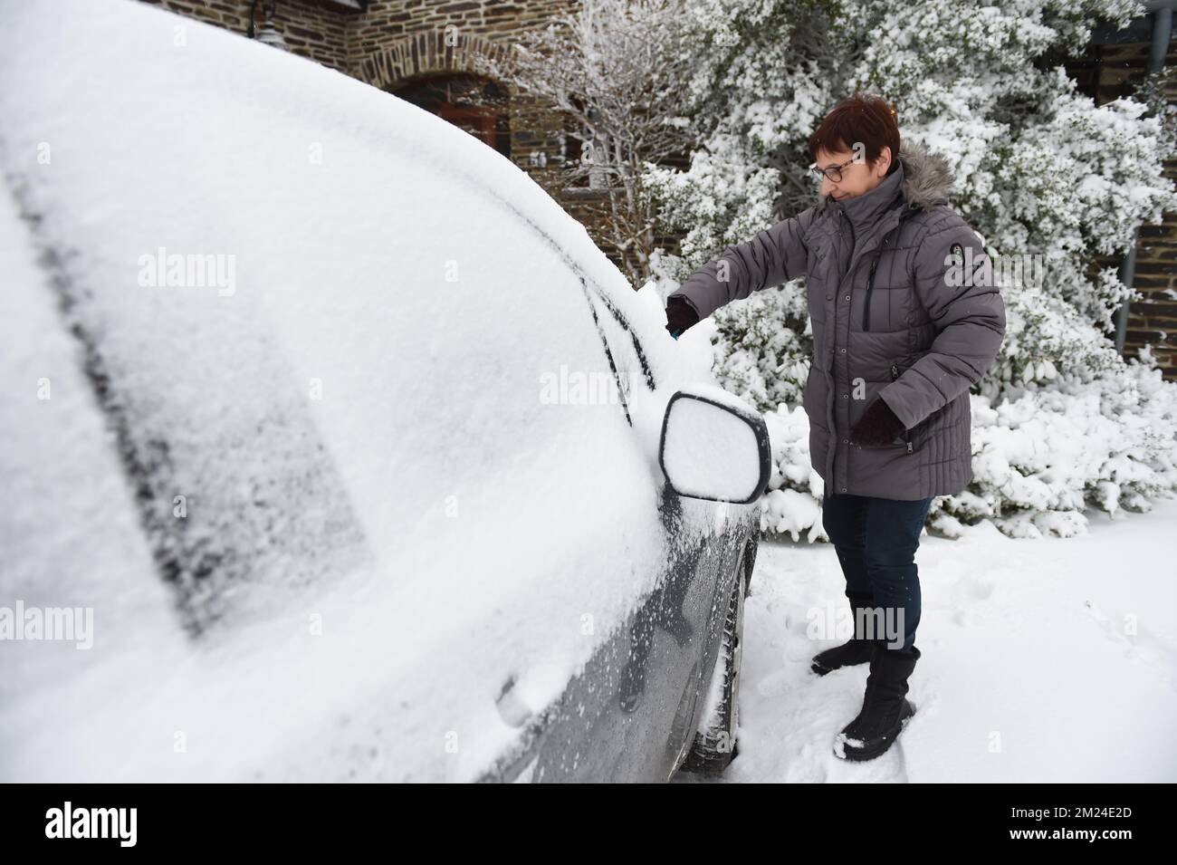 Illustration picture shows a woman removing the snow from her car as ...