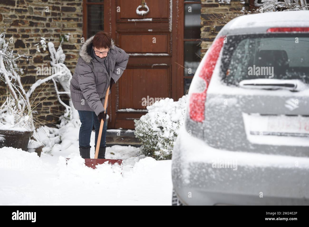 Illustration picture shows a woman removing the snow as cold ...