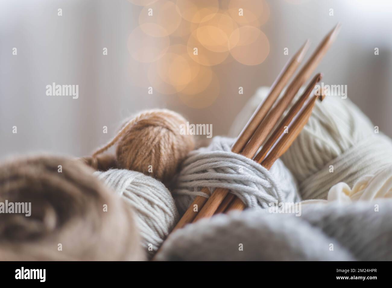 Cozy homely atmosphere. Female hobby knitting. Yarn in neutral colors ...