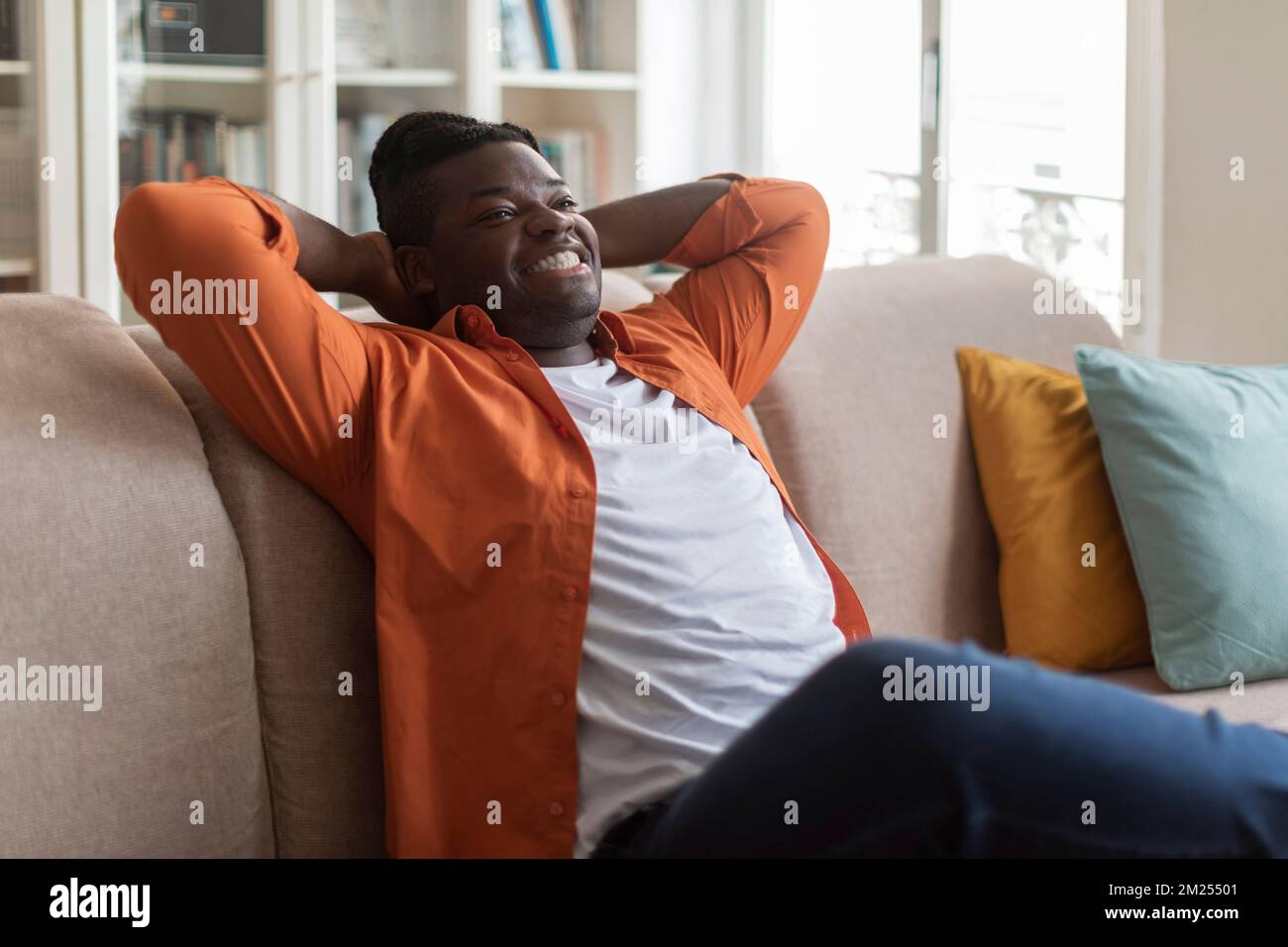 Happy african millennial guy in casual outfit reclining on couch Stock ...