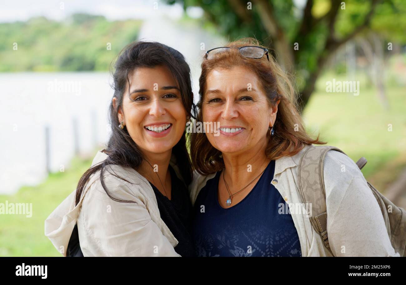 A Hispanic and Caucasian mother with daughter smiling to the camera on ...