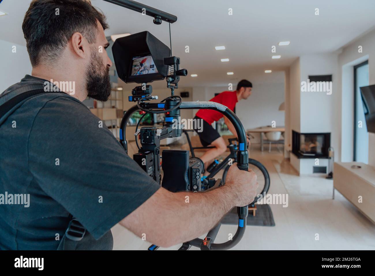 A cameraman filming an athlete riding a triathlon bike on a simulation ...