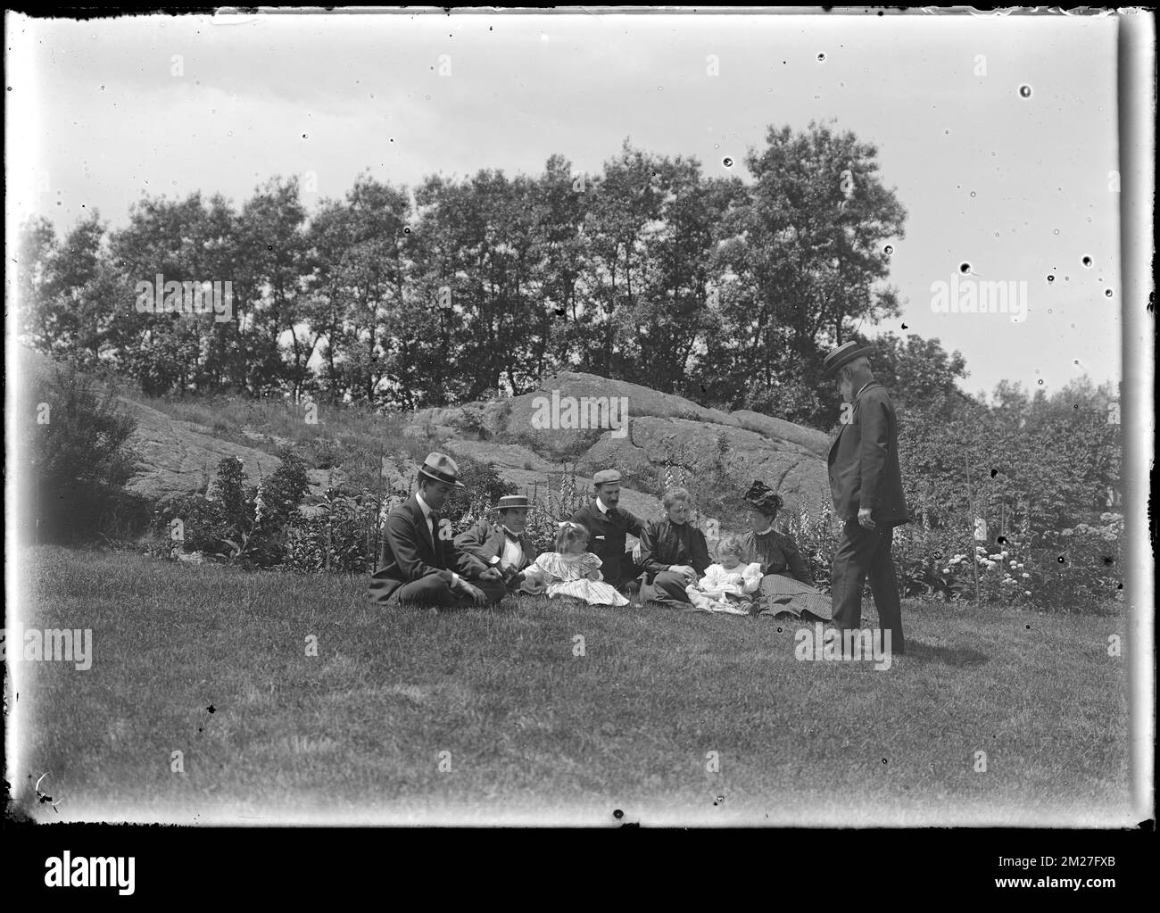 Charles W. Parker (standing) with others seated on the ground ...