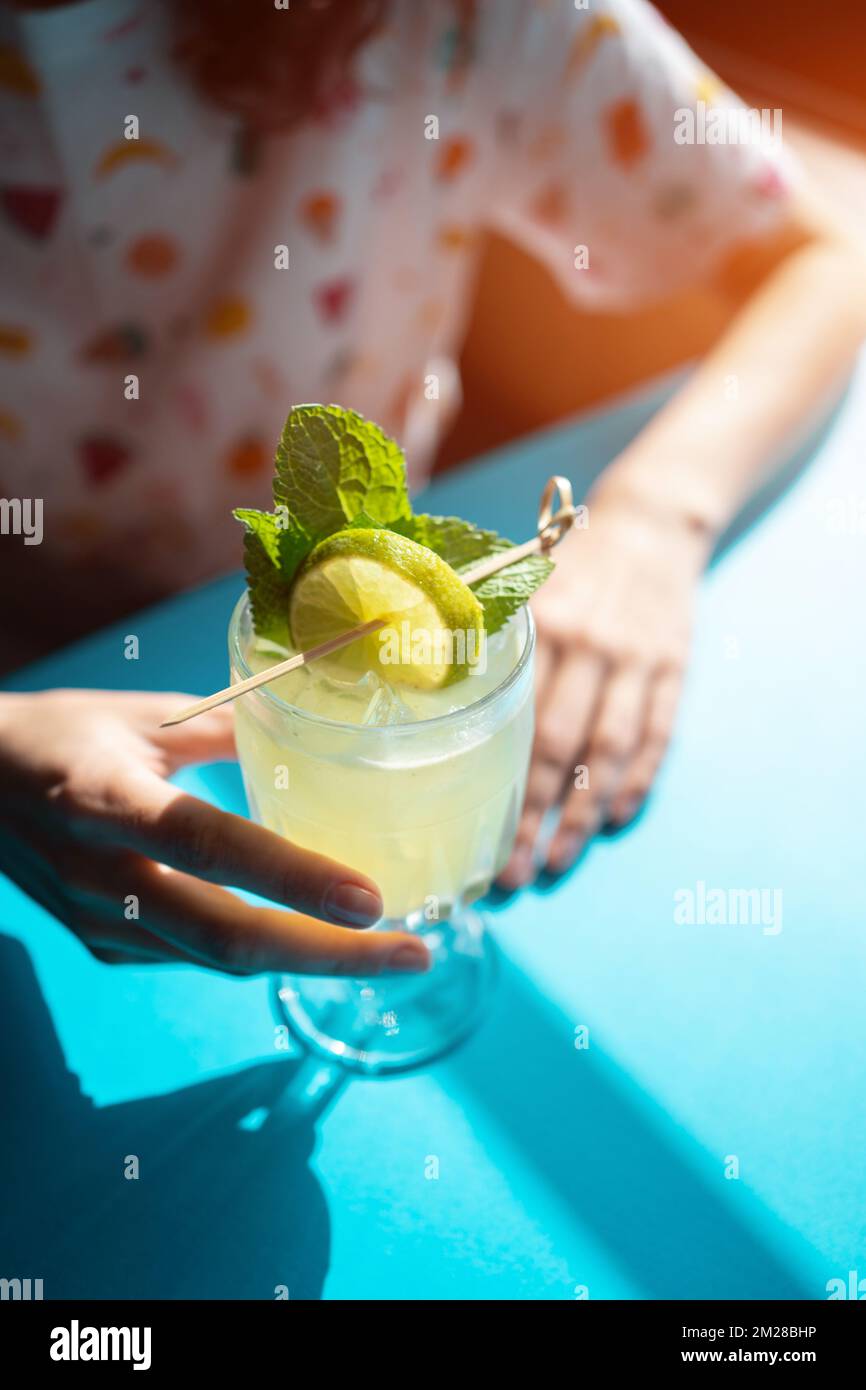 female drink yellow alcohol cocktail with lime, mint, ginger, honey in ...