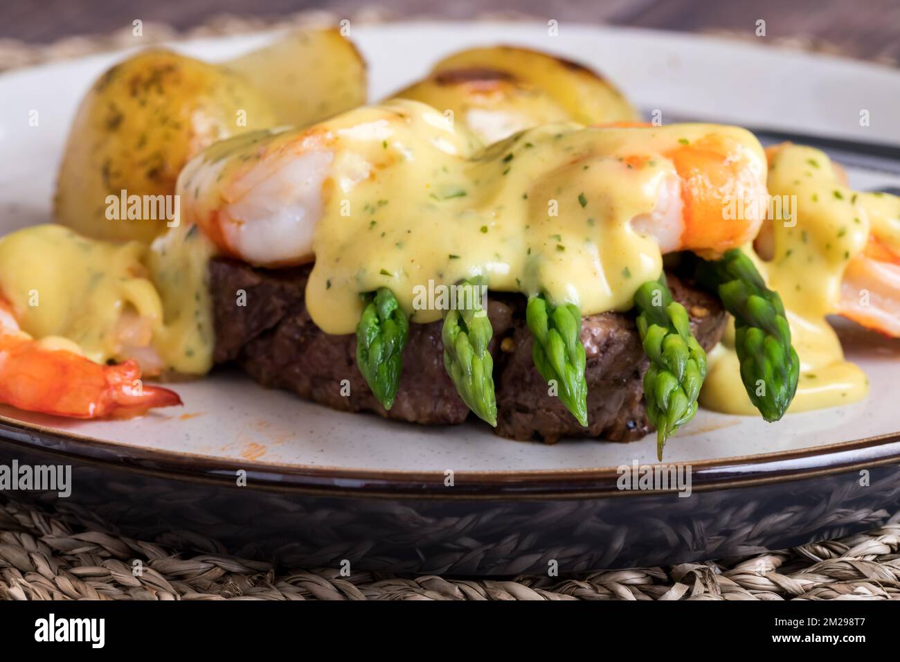 A plate of Steak Oscar with jumbo prawns and served with roasted ...