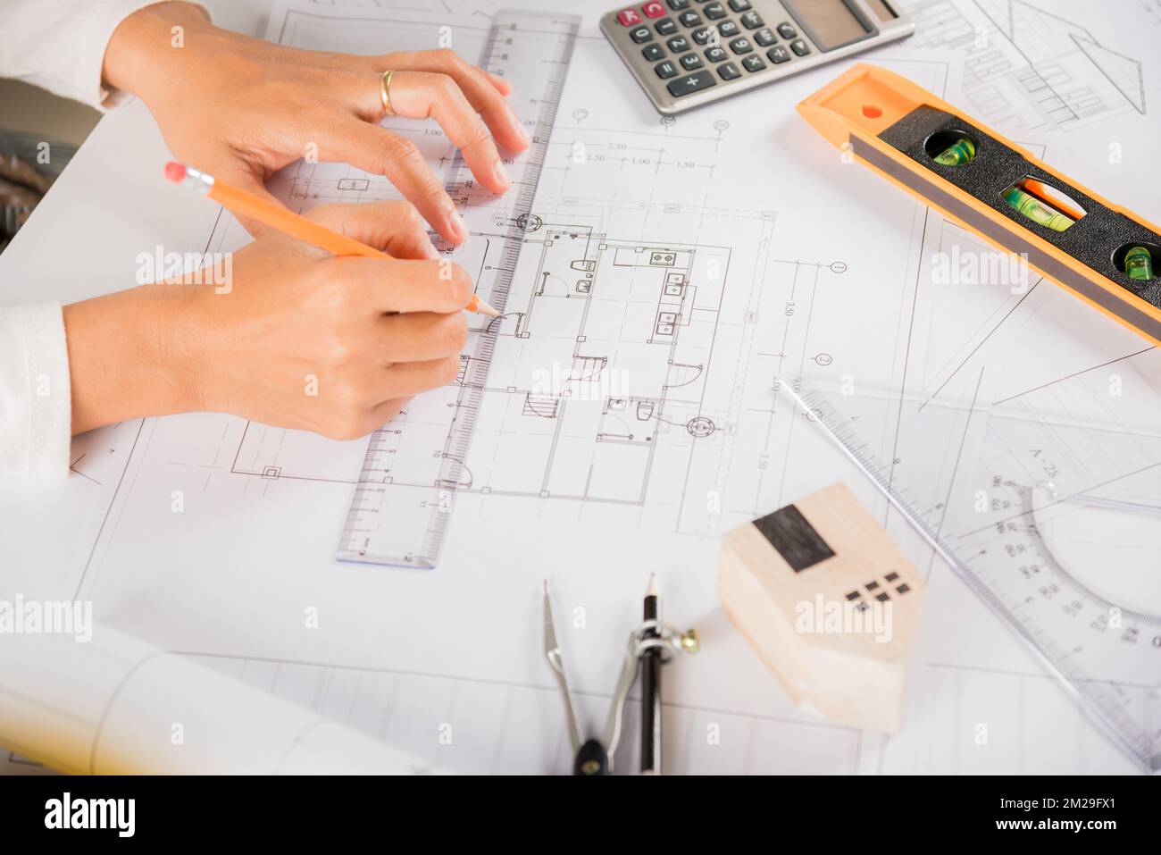 Architect drawing with ruler on house plan blueprint paper for repair ...