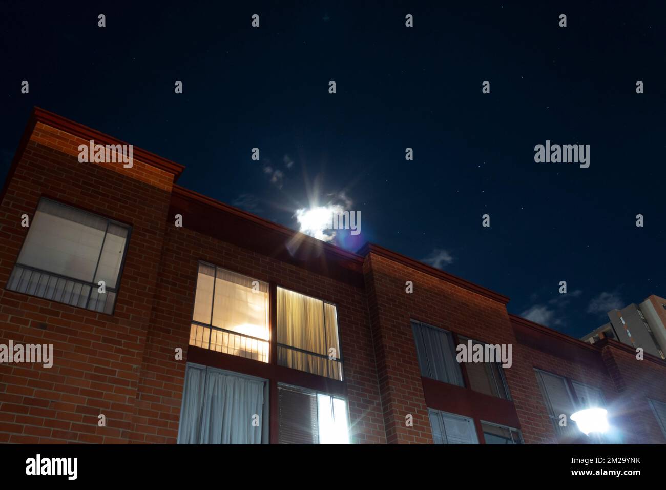 brick house with artificial lights and full moon starry nights Stock ...