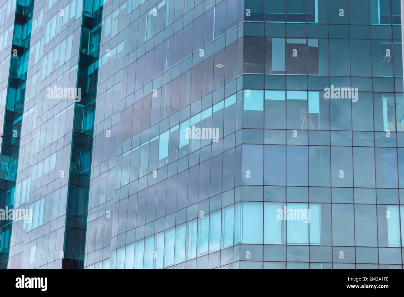 closeup to a modern blue skyscraper windows reflection white clouds and ...