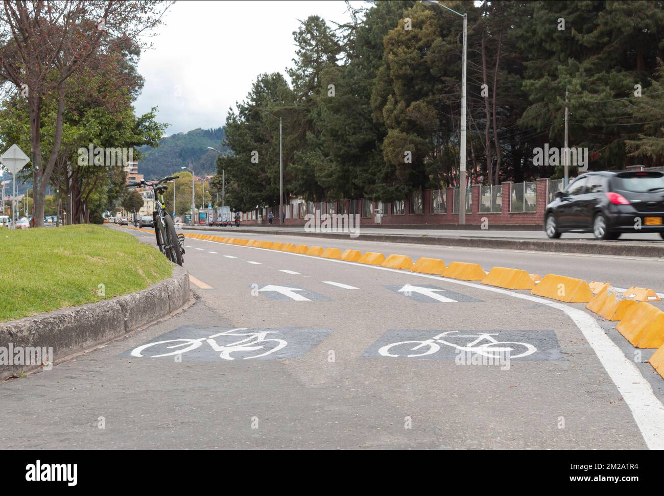 Bike path in middle of a highway with a black mountain bike trees and a ...