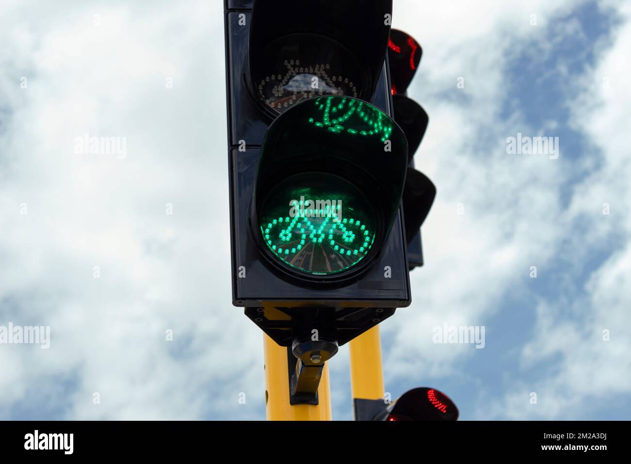 Closeup to a green traffic light near to a vehicular traffic light in a ...