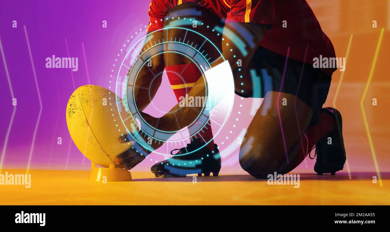 Low section of african american rugby player with ball kneeling on ...