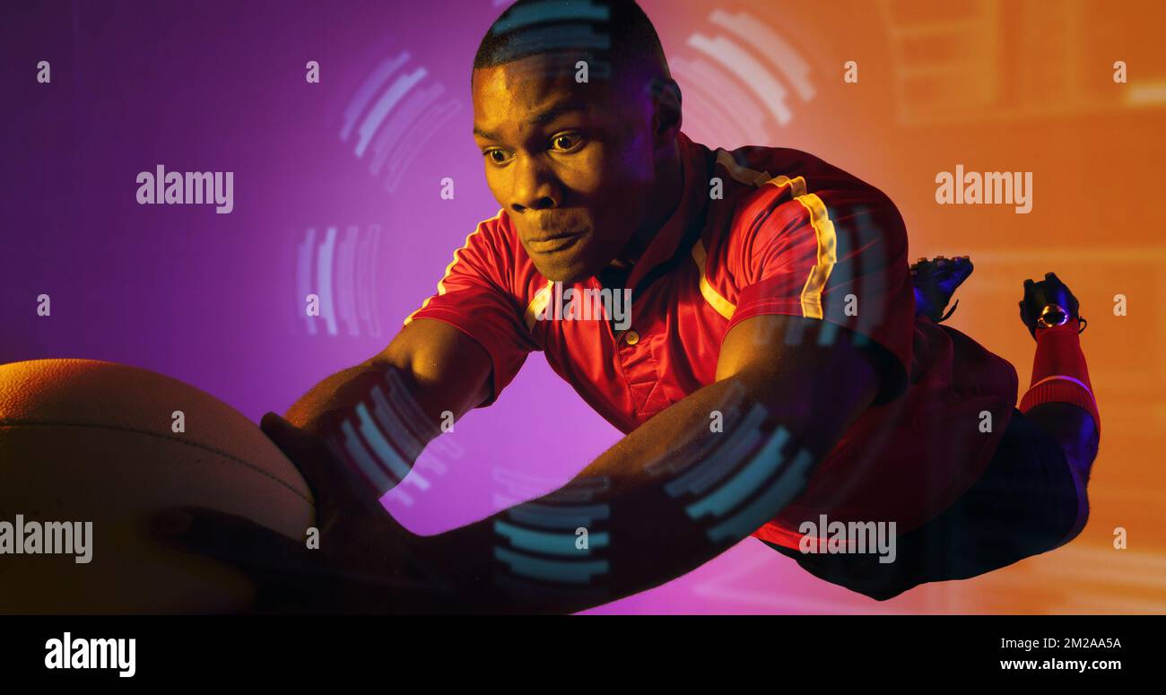 African american rugby player jumping and catching ball over circular ...