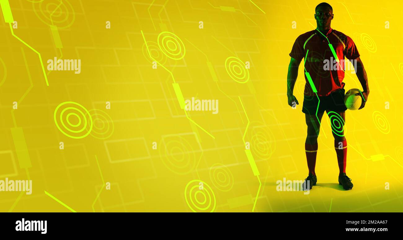 African american rugby player holding ball standing by geometric shapes ...