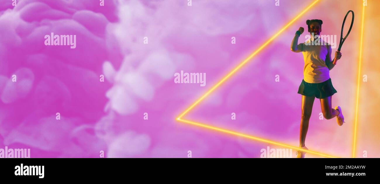 African american female tennis player holding racket and jumping by ...