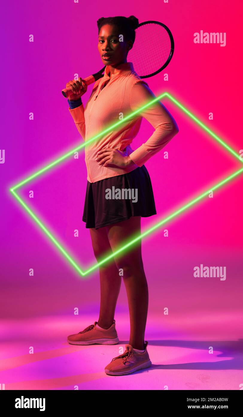 African american tennis player holding racket by illuminated rectangle ...