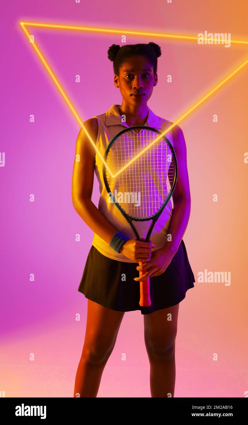 Confident african american female tennis player holding racket by ...