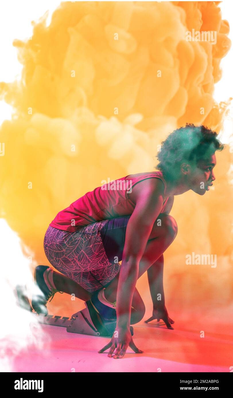 Side view of african american female athlete crouching at starting ...