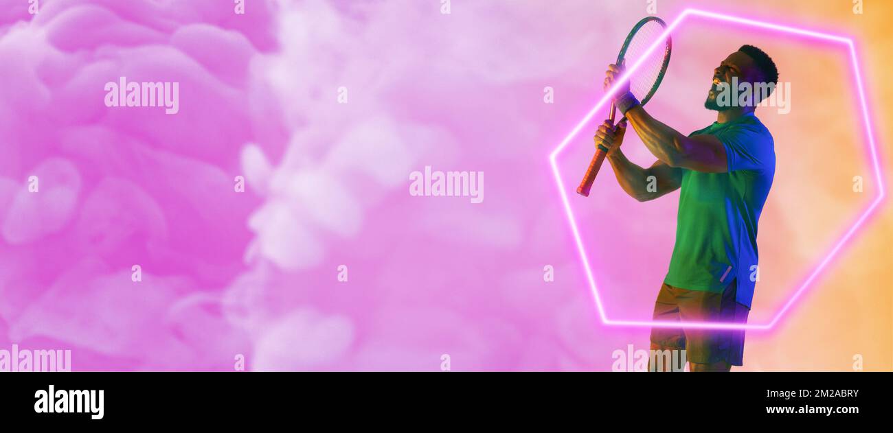 African american male player with racket screaming by illuminated ...