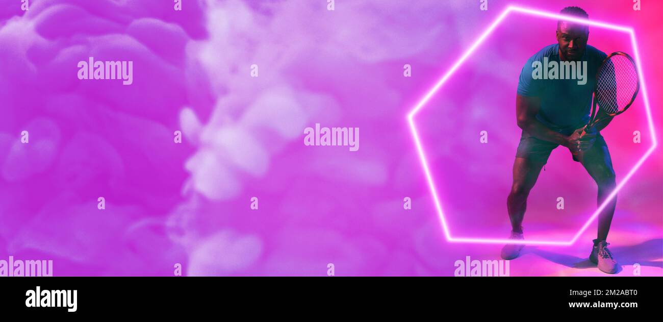 African american male tennis player with racket standing by illuminated ...