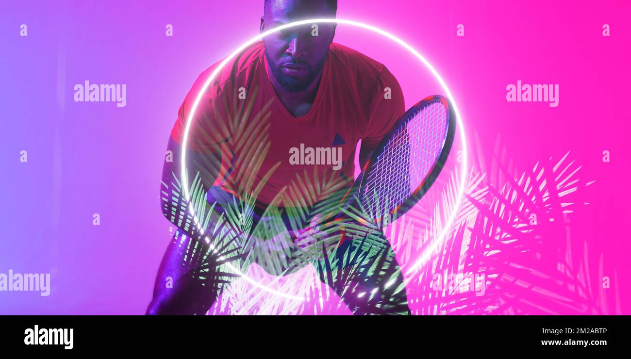 Illuminated circle and plants over african american male player holding ...