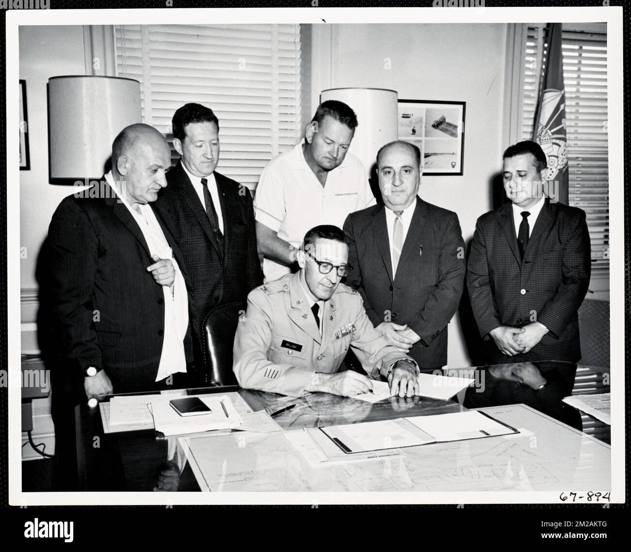 Col. Kellogg signing document , Ordnance industry, Armories, Gates ...